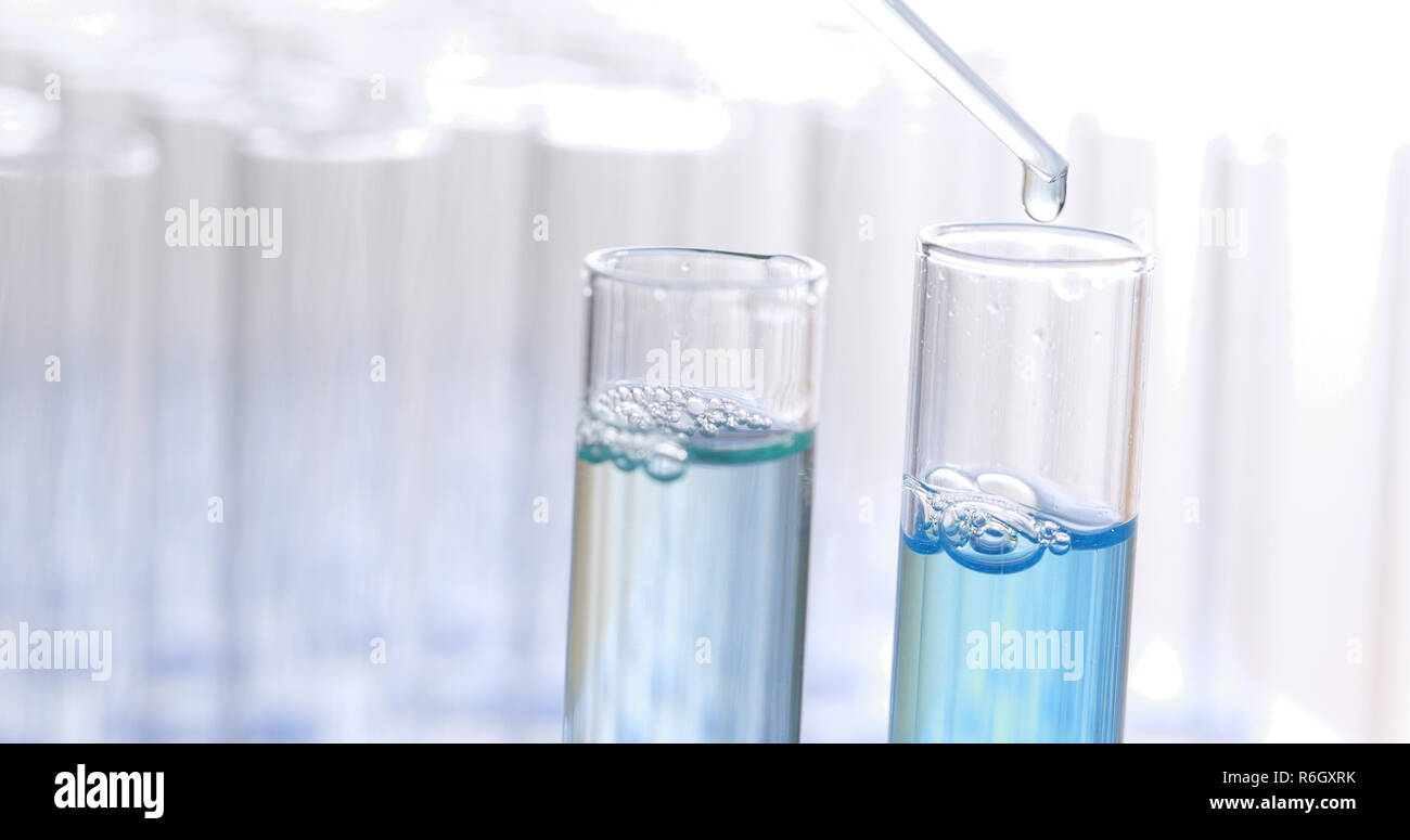 Pipette drips blue chemicals into a test tube Stock Photo - Alamy
