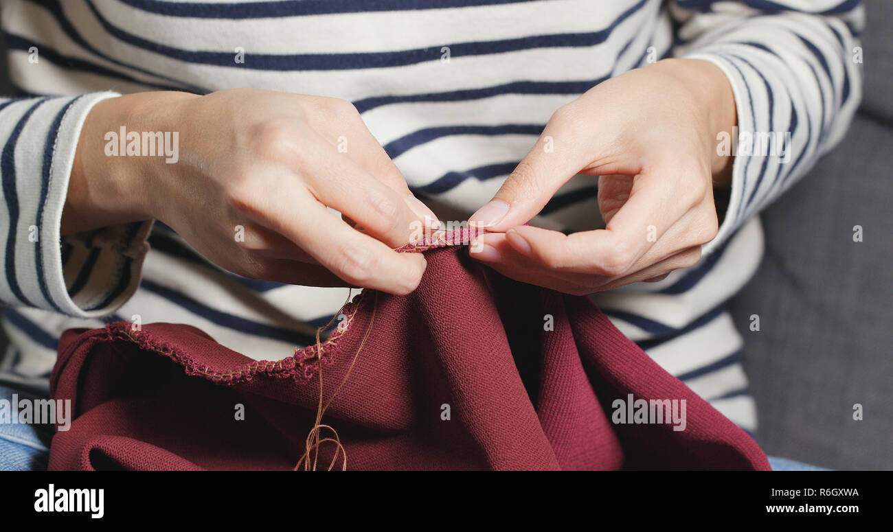 Hand Sews with a needle and thread at home Stock Photo - Alamy