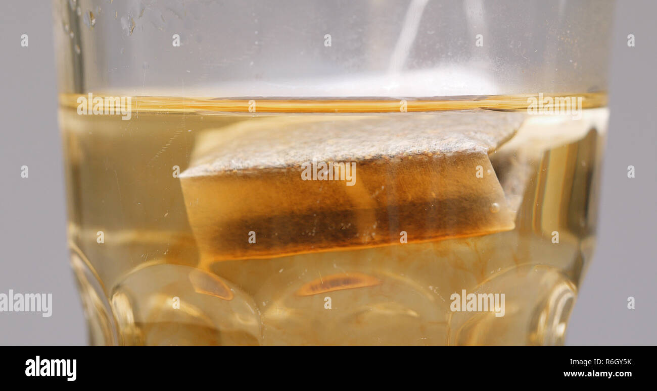 Putting tea bag into hot water Stock Photo - Alamy