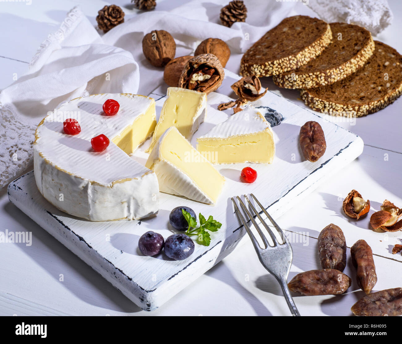 round Camembert cheese, slices of smoked sausage and bread Stock Photo ...