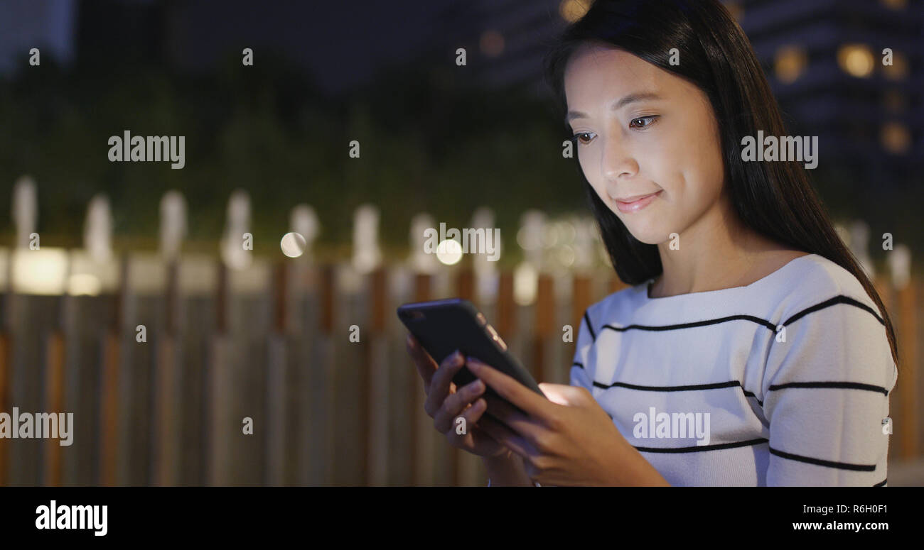 Woman using mobile phone online at night Stock Photo - Alamy