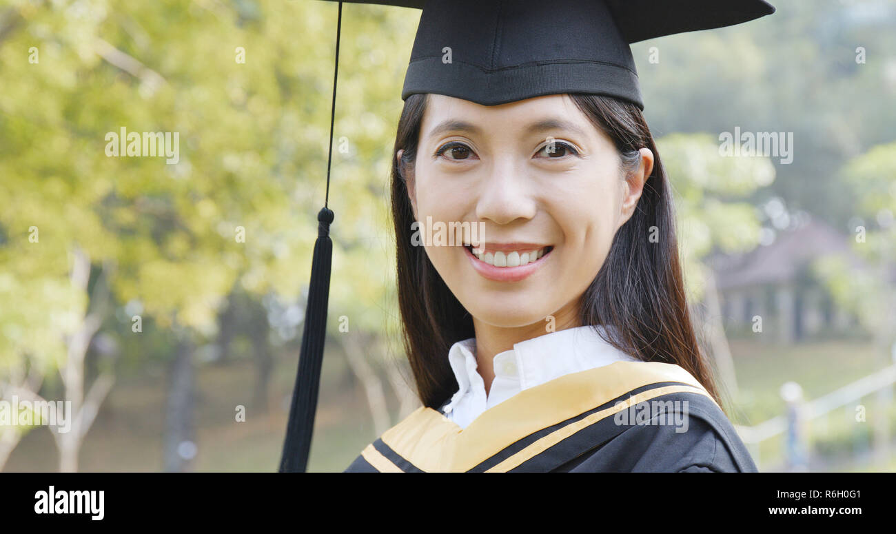 Asian woman wearing graduation gown Stock Photo - Alamy