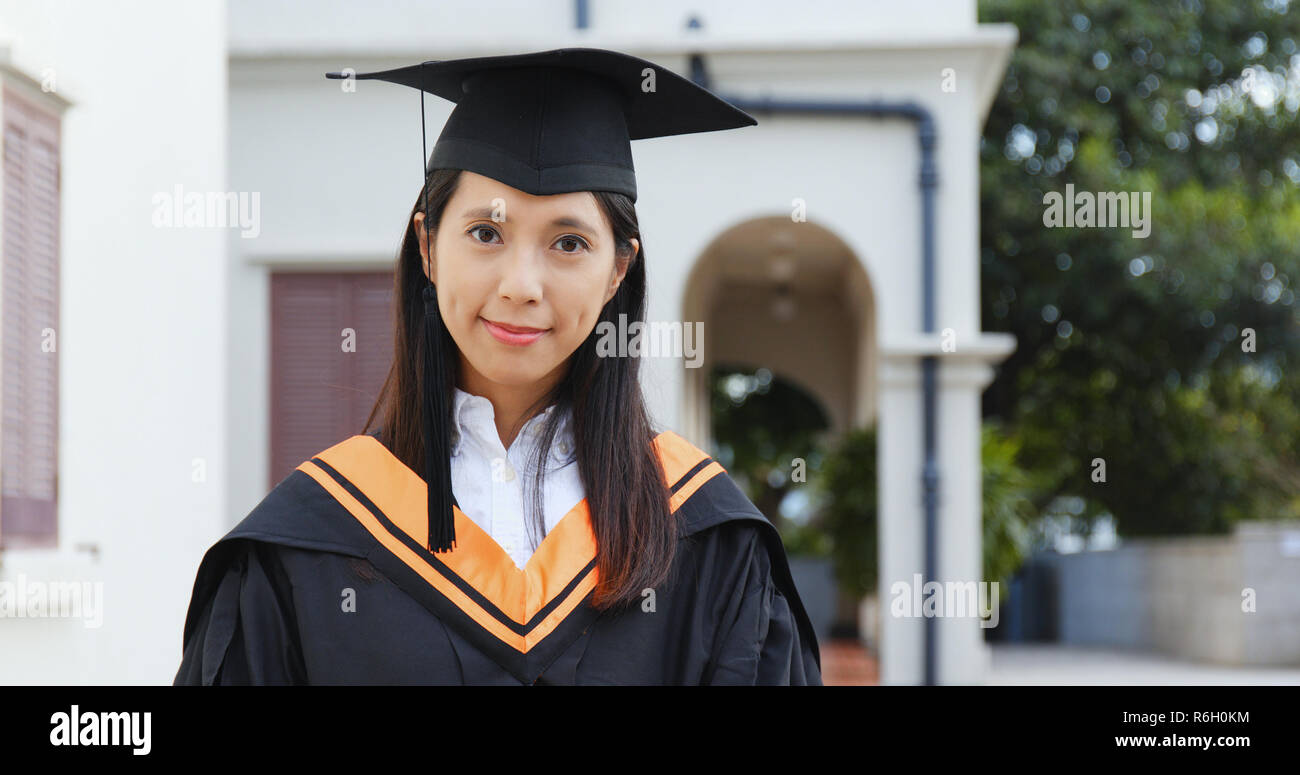 Woman wear graduation gown in campus Stock Photo - Alamy