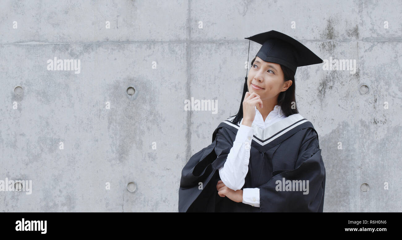 Woman graduation gown and think of future Stock Photo - Alamy