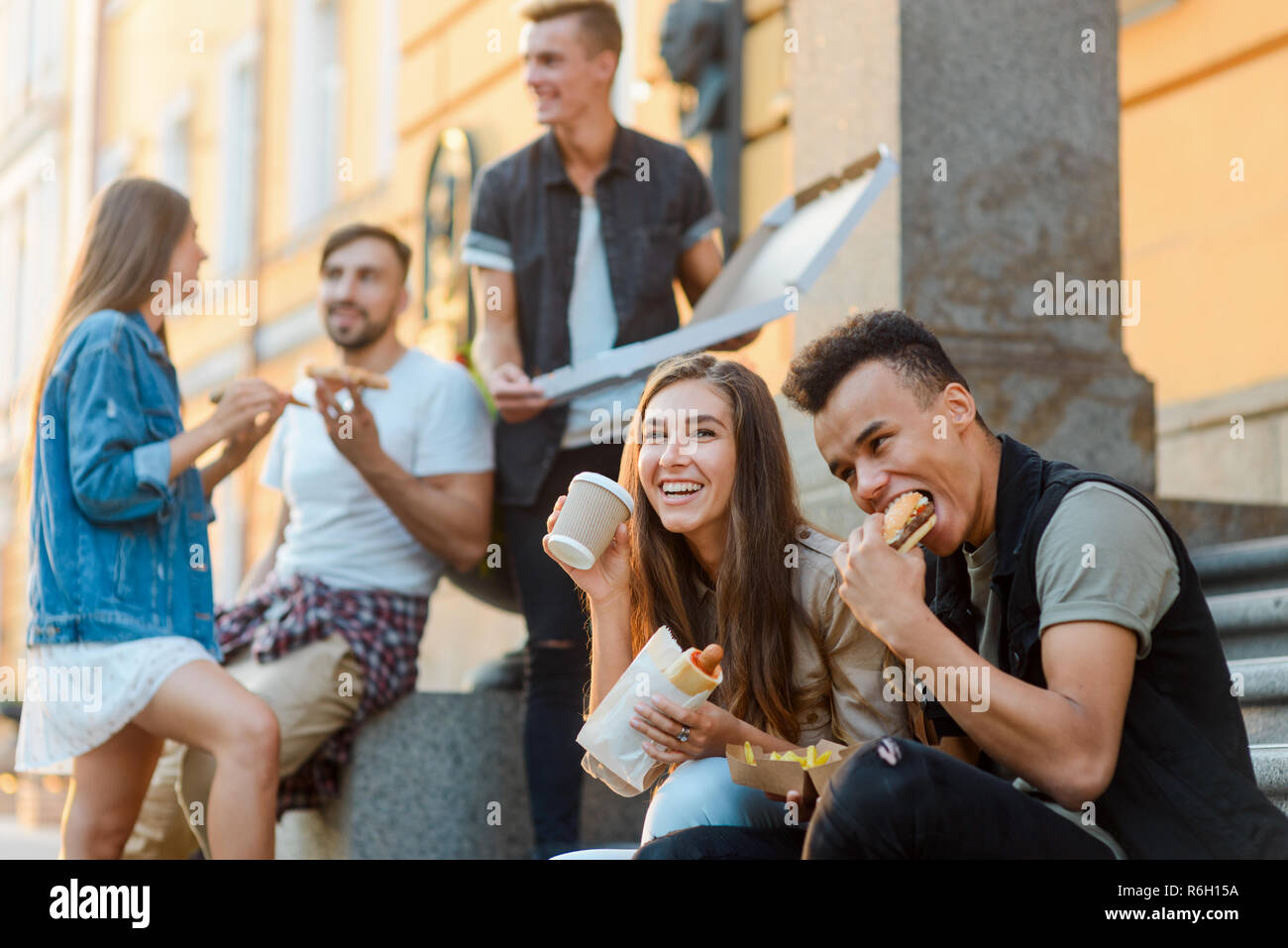Young people eating fast food Stock Photo - Alamy