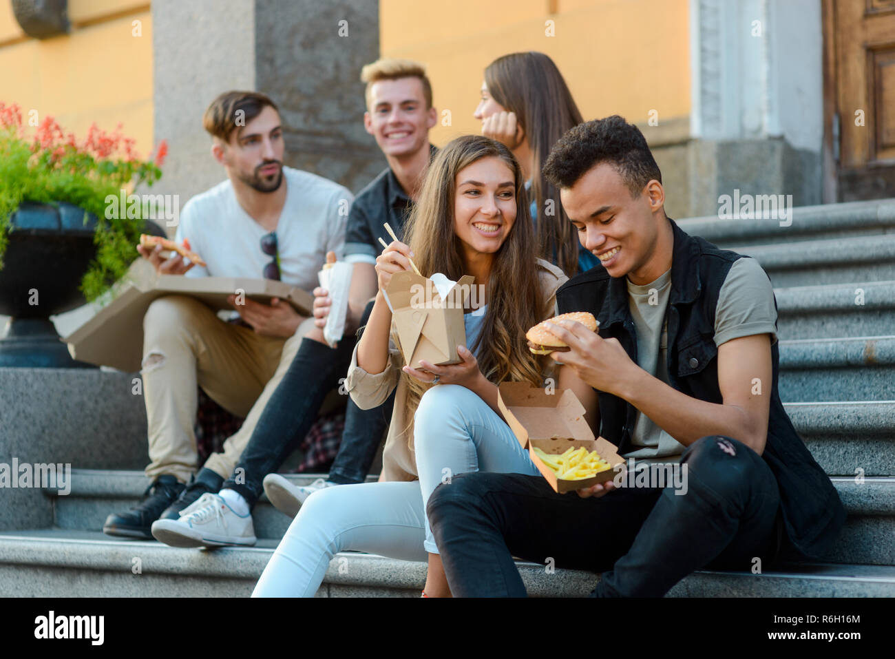 Happy friends enjoying fast food Stock Photo - Alamy