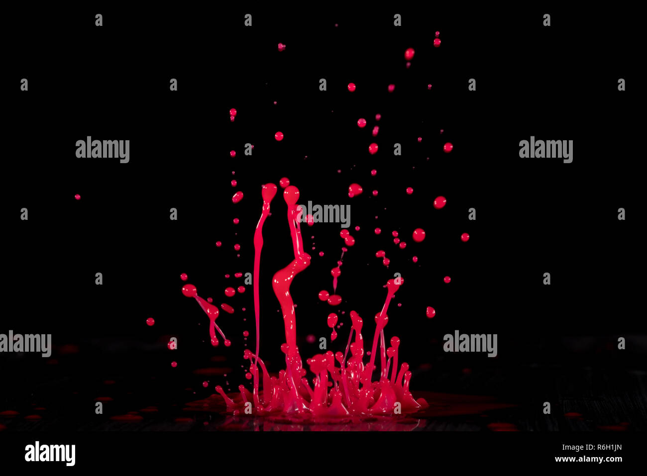 Red paint, ink splash on black background Stock Photo - Alamy