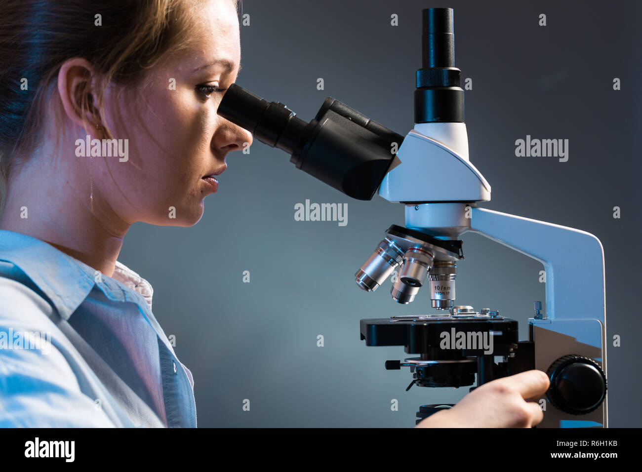 beautiful science student looking into a microscope in a laboratory ...