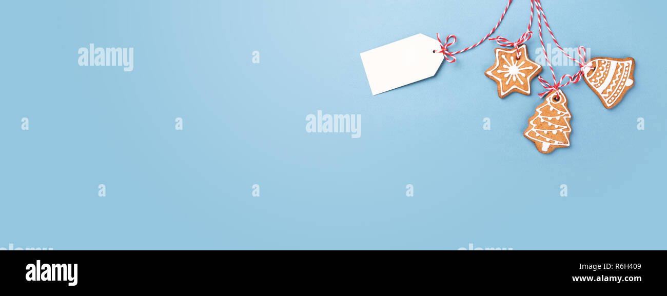 Christmas gingerbread cookies with paper tag hanging over blue ...