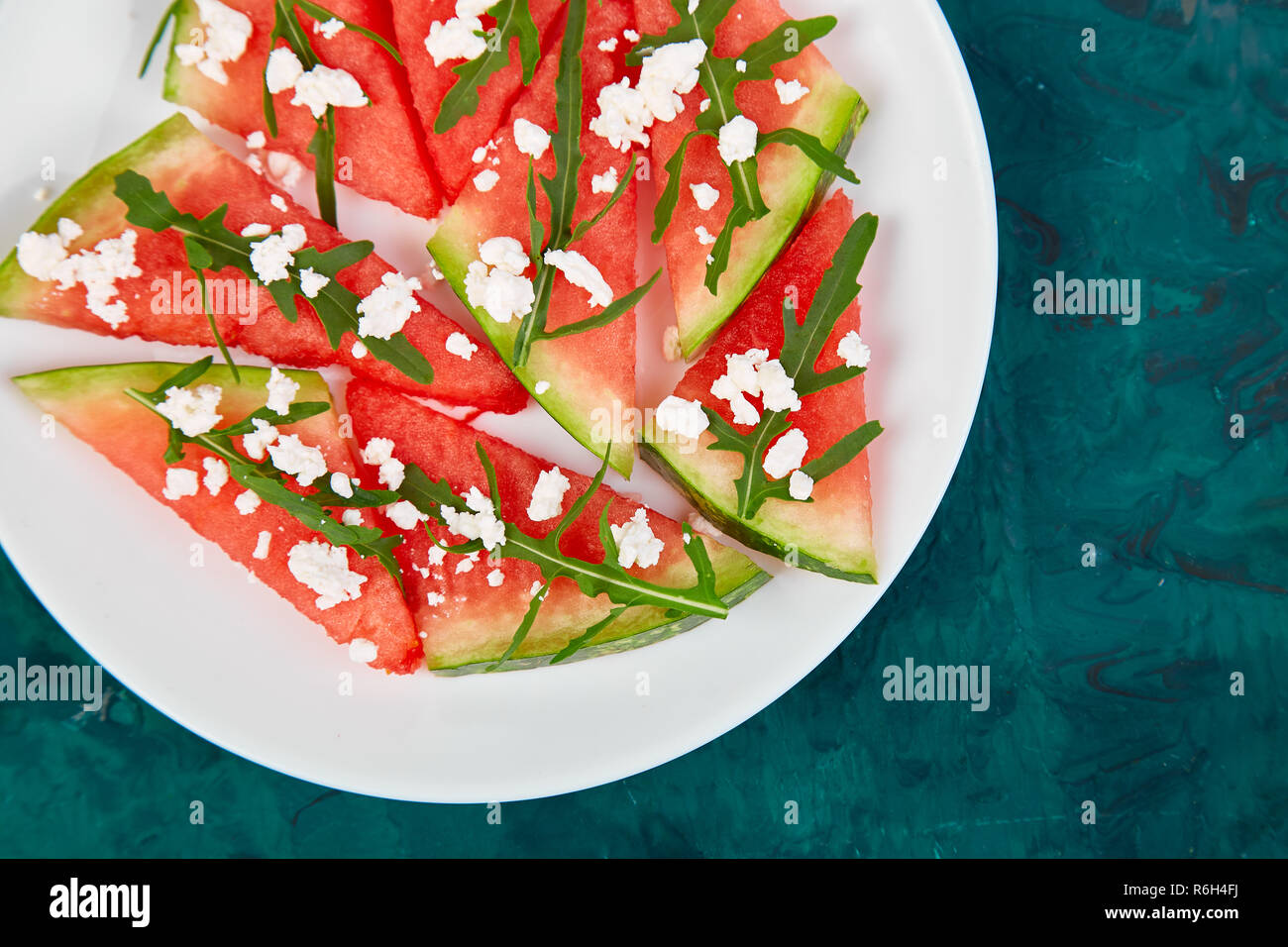 Fresh summer watermelon salad with feta cheese and arugula on green ...