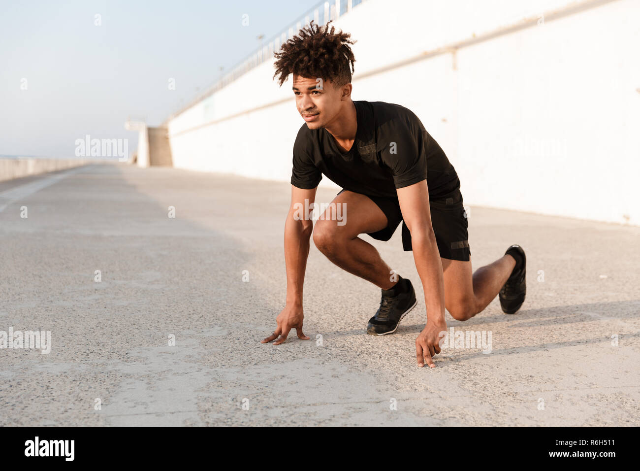 Image of handsome young guy sportsman runner standing ready to start ...