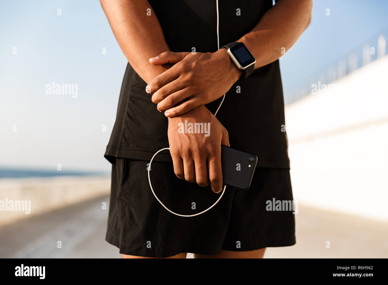 Cropped photo of a young guy sportsman outdoors on the beach holding ...
