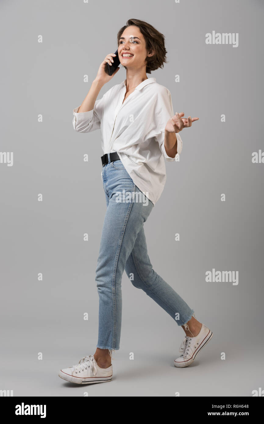 Image of emotional young business woman posing isolated over grey wall ...