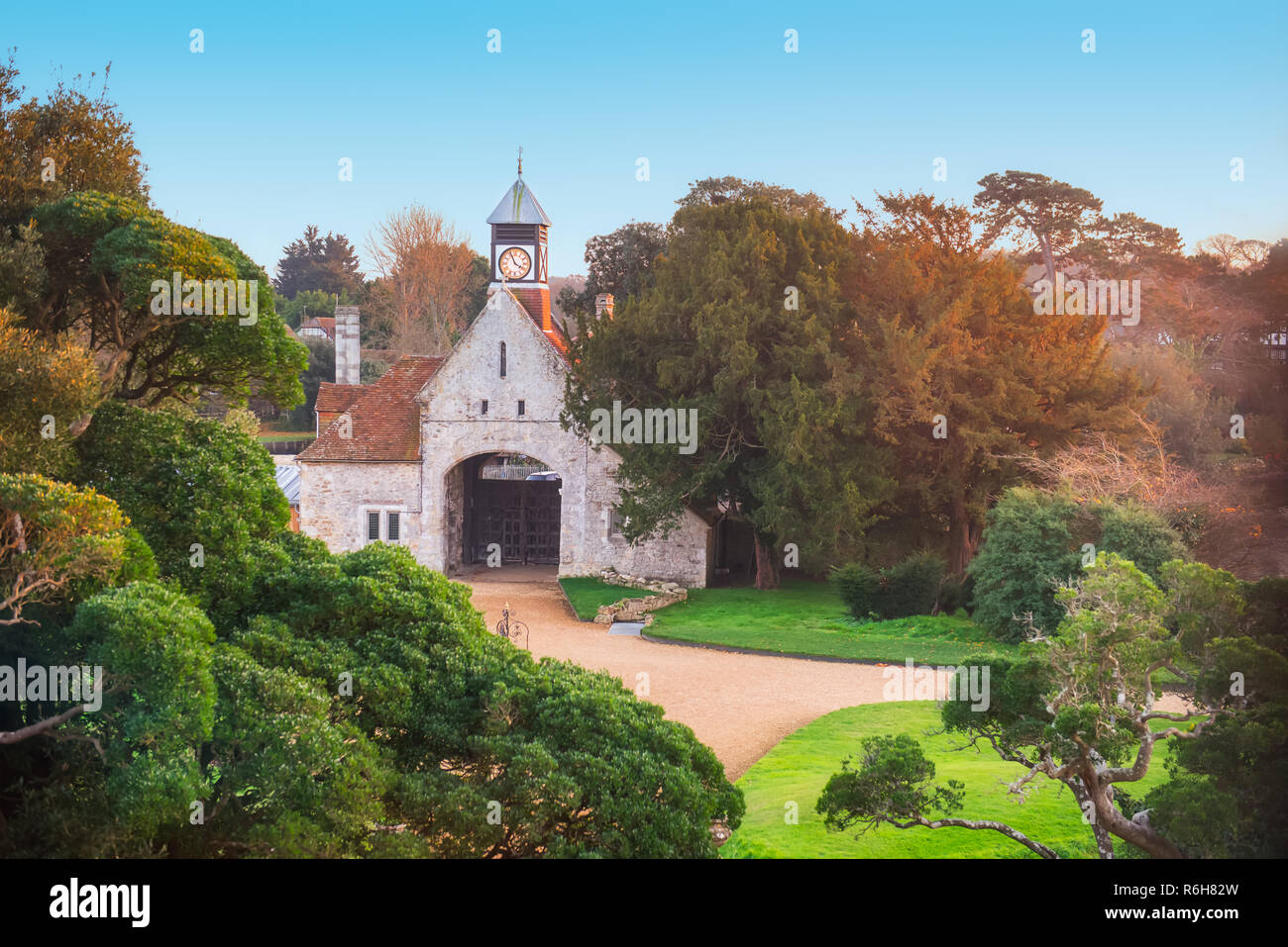 Panoramic landscape with clock tower gate leading to garden in forested ...