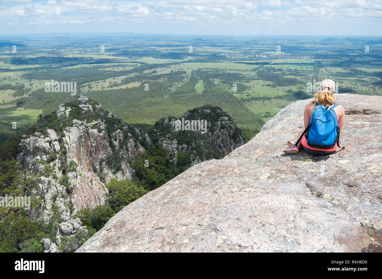 Young beautiful woman looking out over the landscape from the top of ...