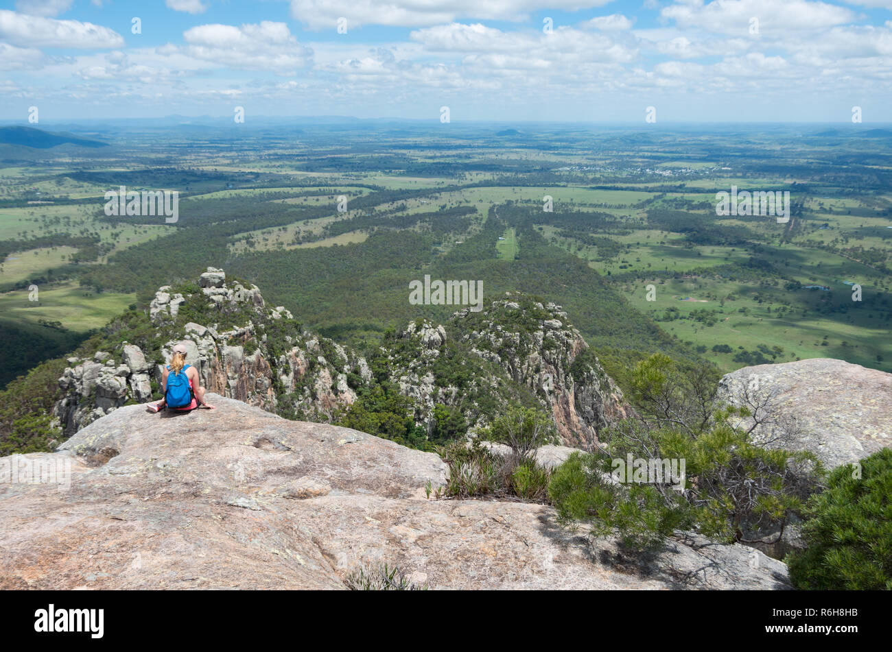Young beautiful woman looking out over the landscape from the top of ...