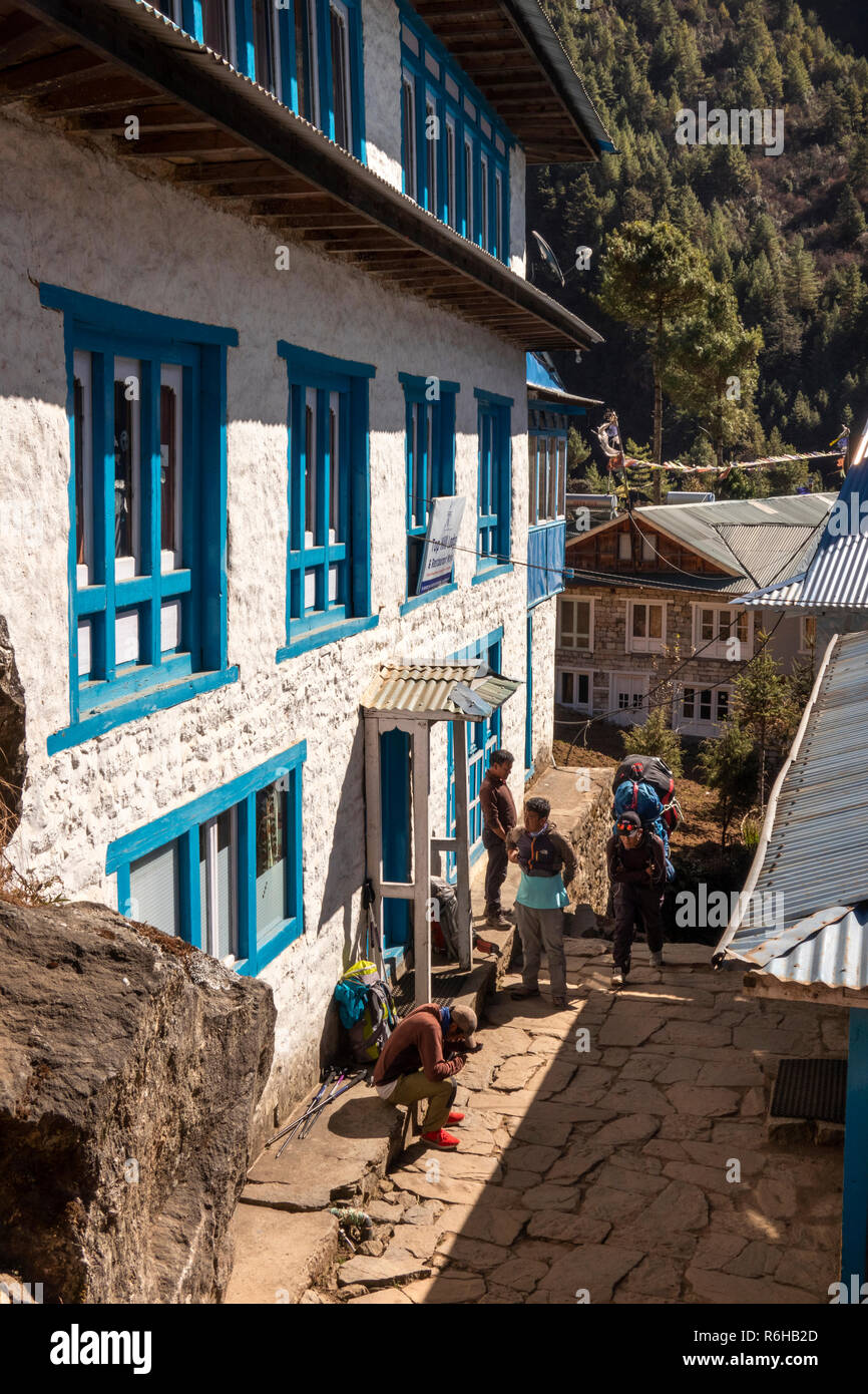 Nepal, Monju, (Manjo) village, people sat in sunshine outside houses ...