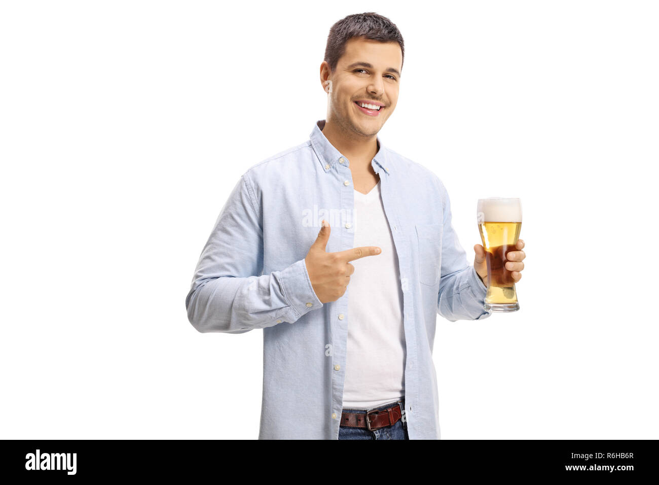 Handsome young man holding a pint of beer and pointing at it isolated ...