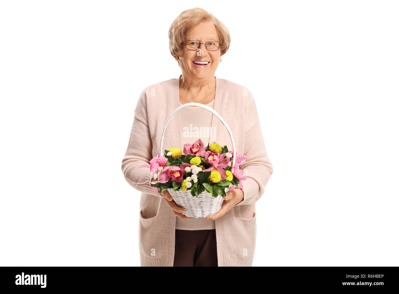 Elderly woman holding a basket with flowers isolated on white ...