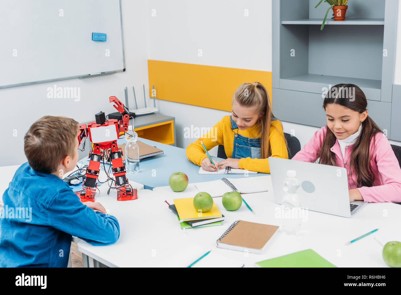 schoolchildren writing and using laptop at STEM robotics lesson Stock ...
