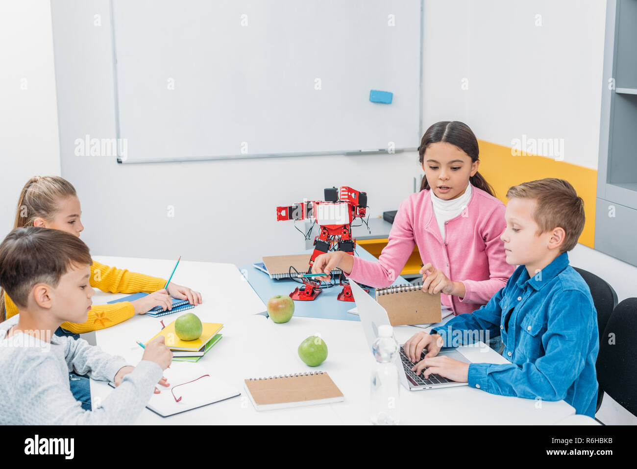 children writing in notebooks and using laptop in stem class Stock ...