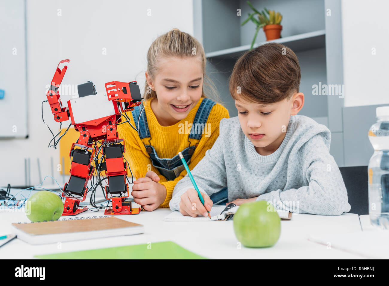 schoolchildren writing in notebook at STEM robotics lesson Stock Photo ...