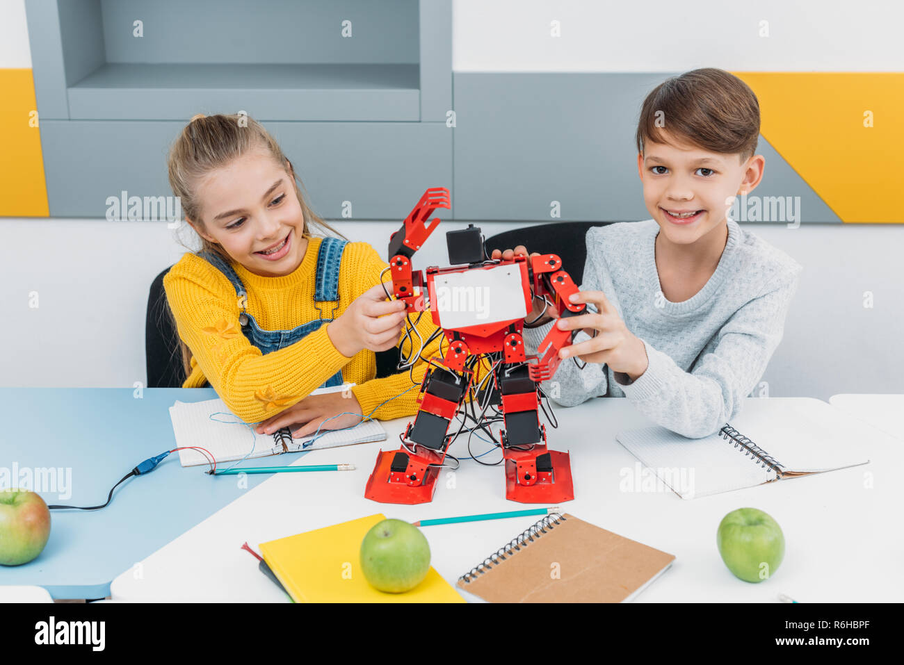 happy classmates presenting robot during STEM robotics lesson Stock ...