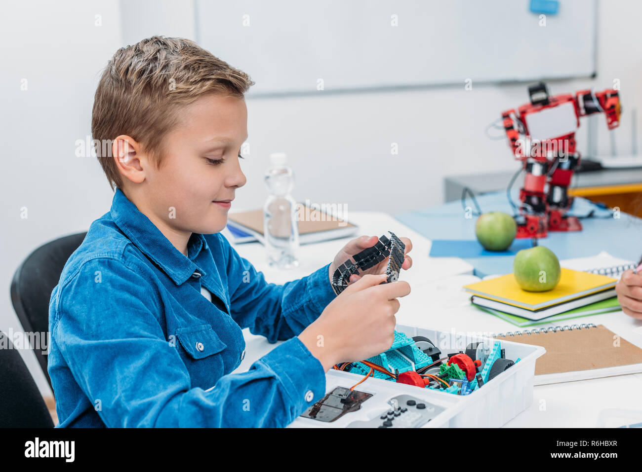 cute schoolboy making mechanical robot with details in stem class Stock ...