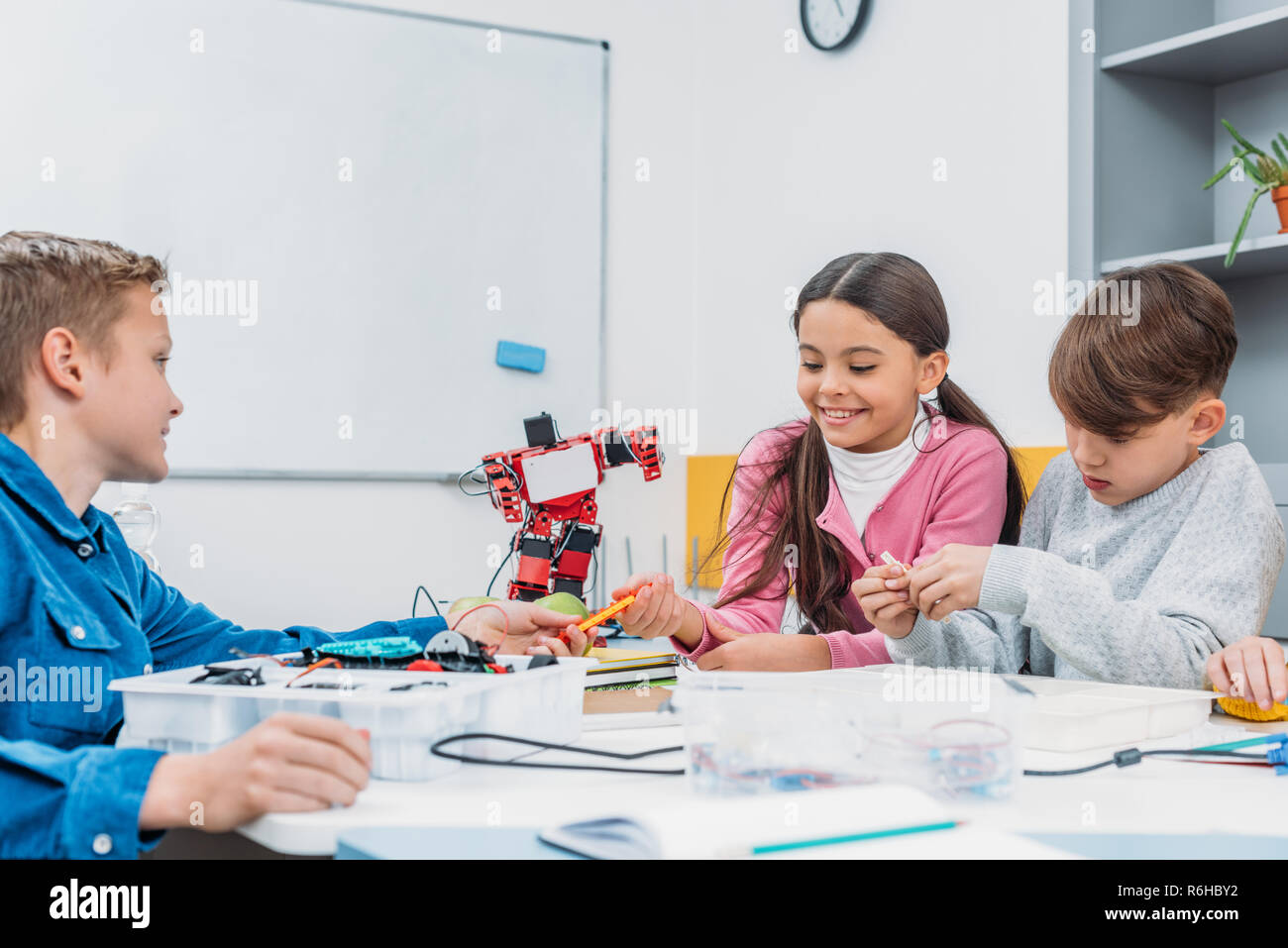 classmates sitting at table, talking and working together on project ...