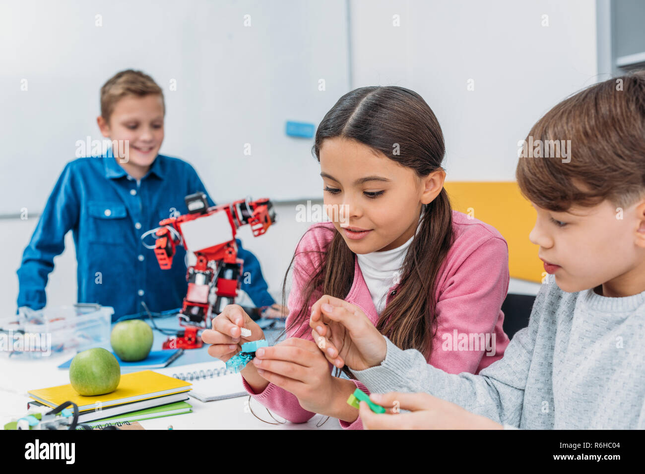 happy classmates making a robot during STEM robotics lesson Stock Photo ...