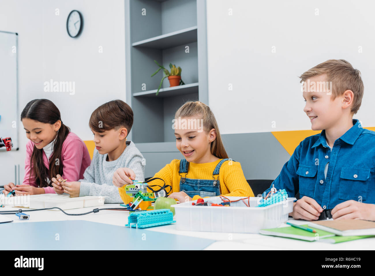 attentive children working with parts of robot at STEM robotics lesson ...