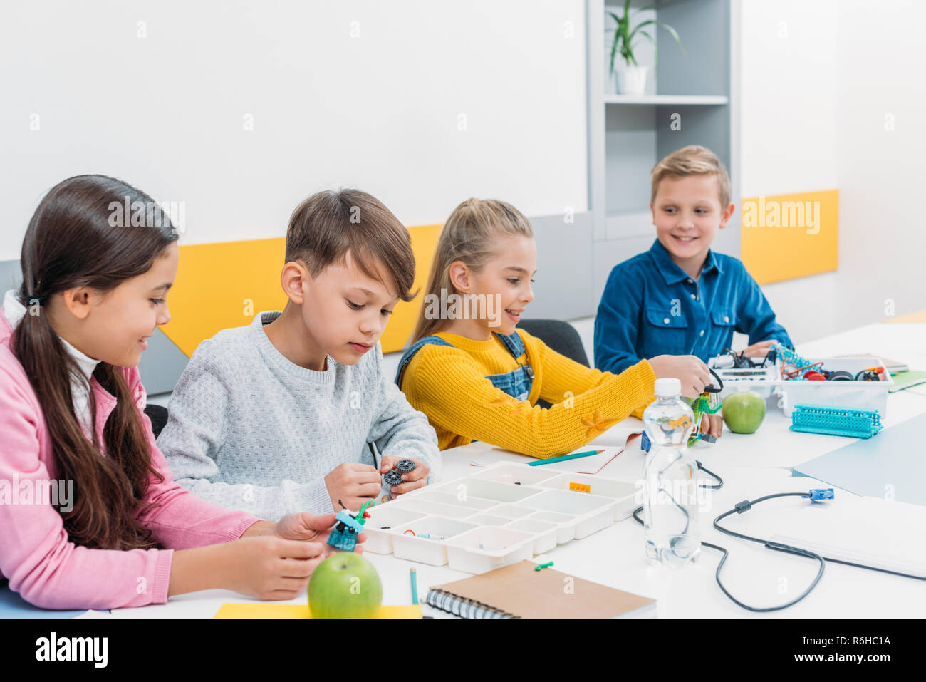 schoolchildren putting a robot together during STEM robotics lesson ...