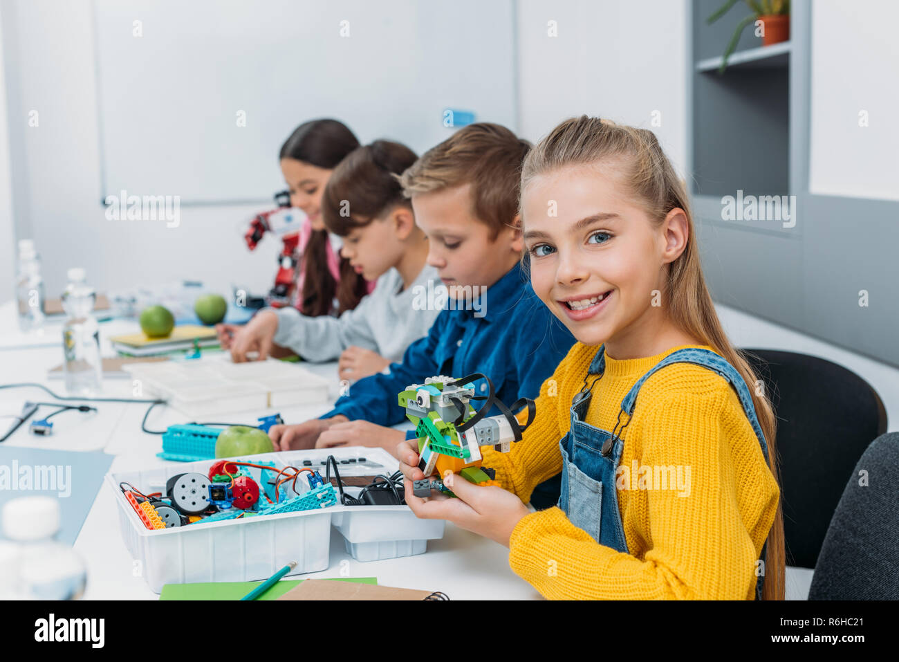 cheerful classmates making a robot during STEM robotics class Stock ...