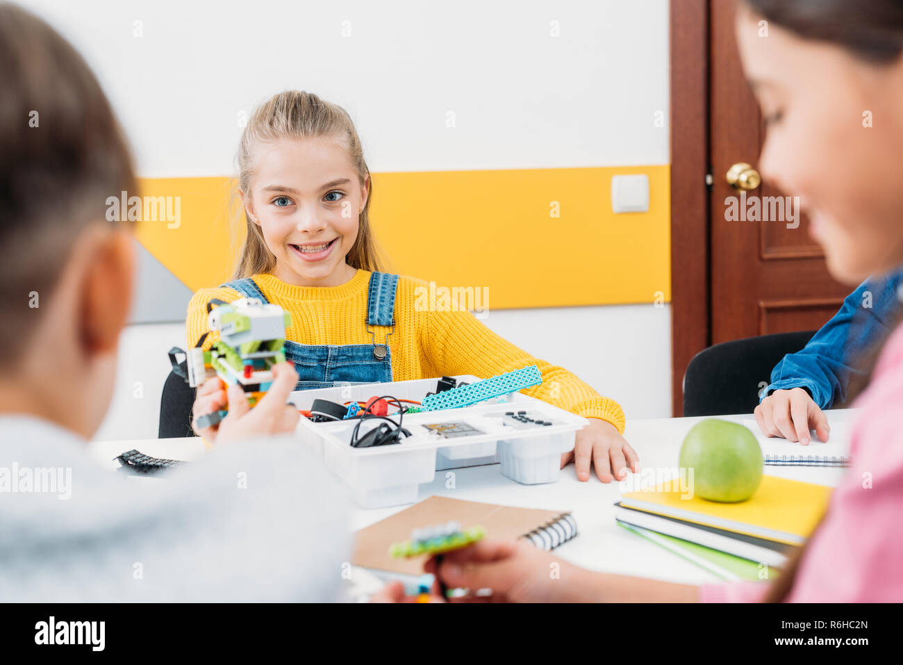 Selective focus of schoolgirl working with classmates together on STEM ...