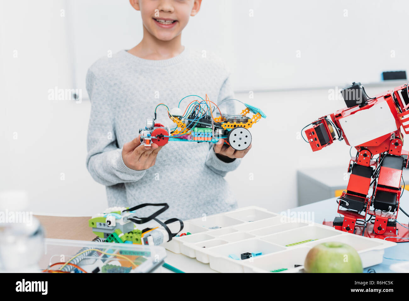 cropped view of schoolboy presenting handmade robot model at STEM ...