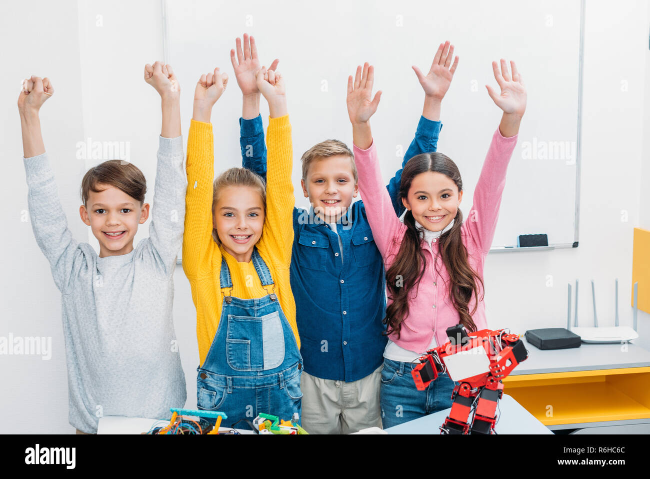 Kids raising hands in class hi-res stock photography and images - Alamy