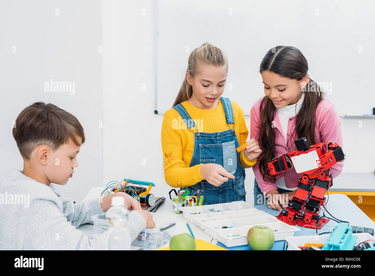 schoolchildren programming robot together during STEM educational class ...