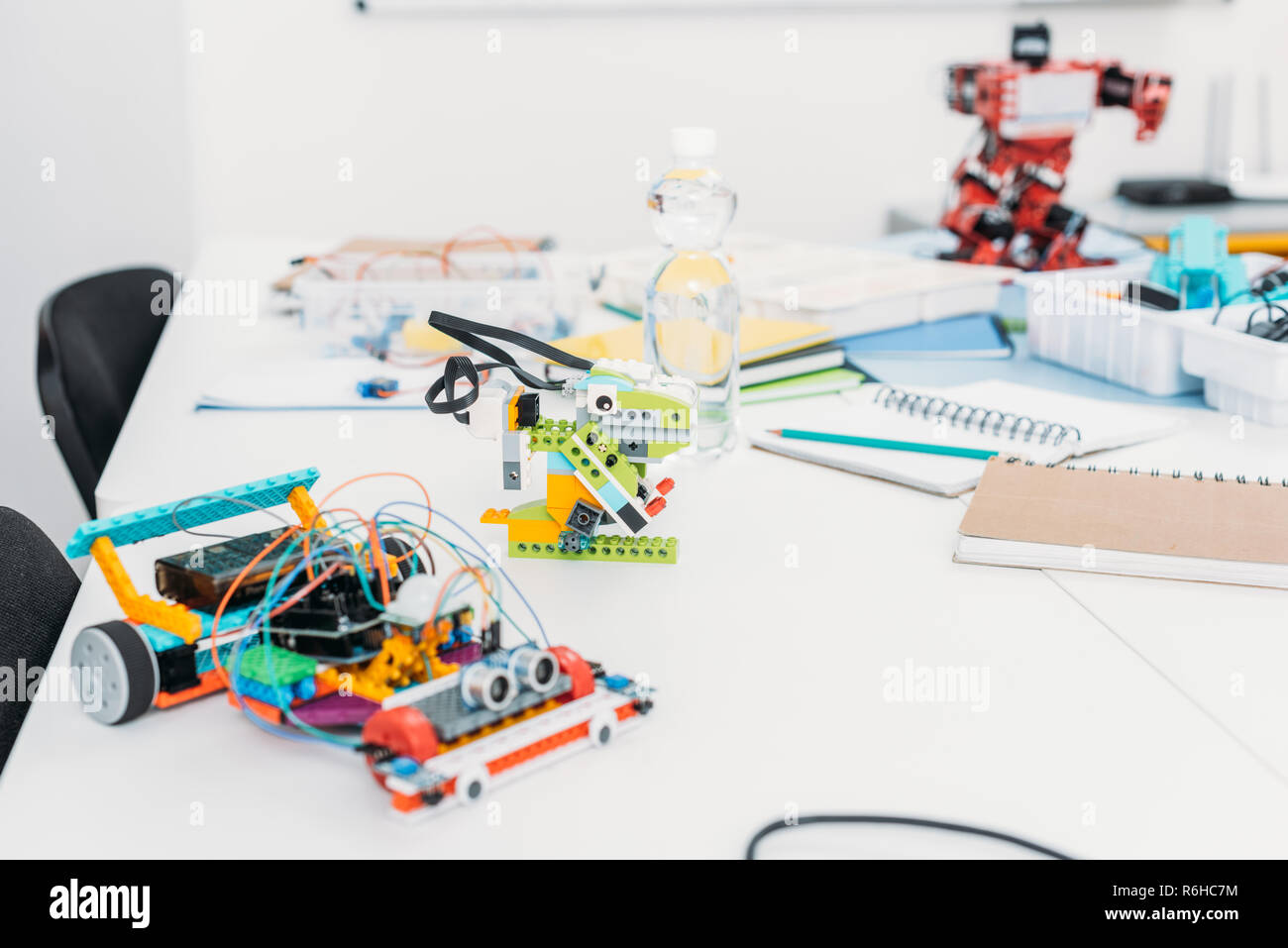 handmade robot models and school supplies on table in STEM classrom ...