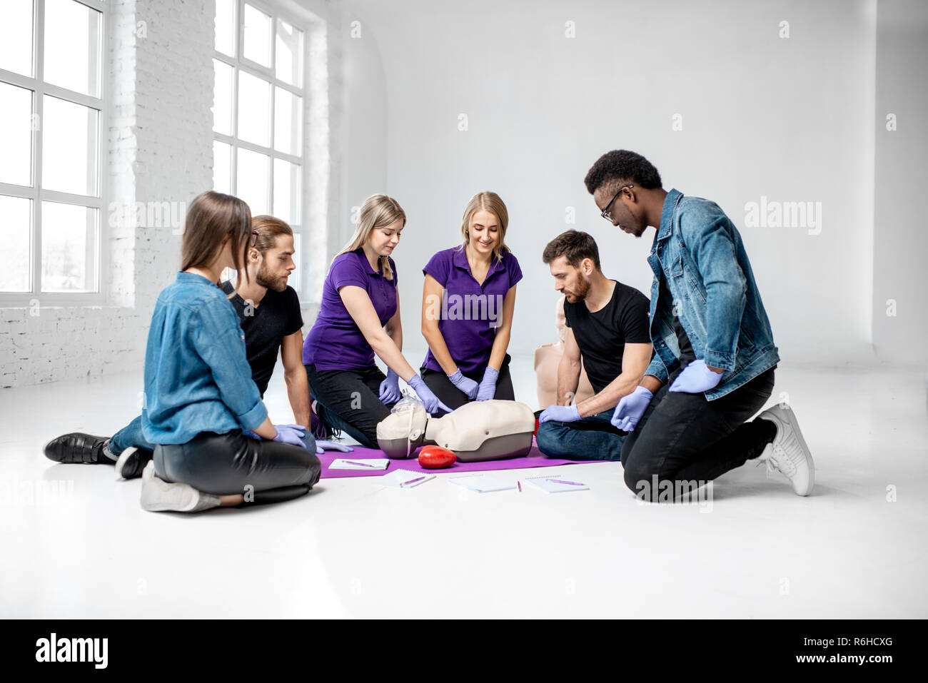 Group of young people learning to make artificial breathing with ...