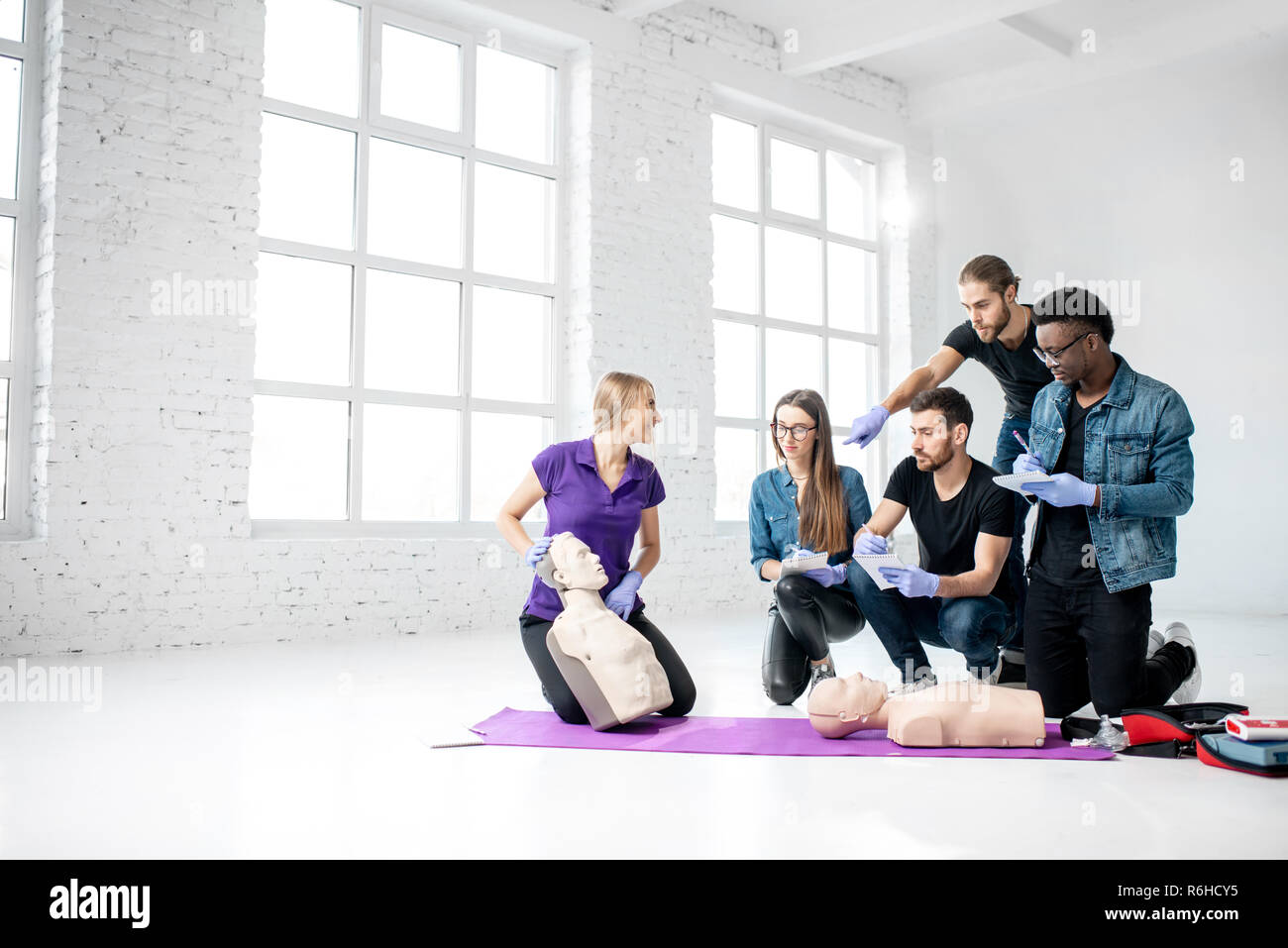 Group of young people learning to make artificial breathing with ...