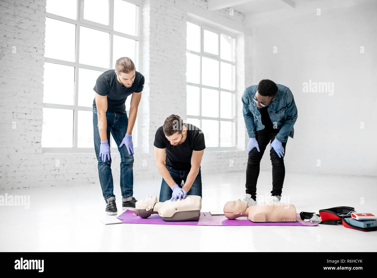Group of young people practising to make artificial breathing with ...