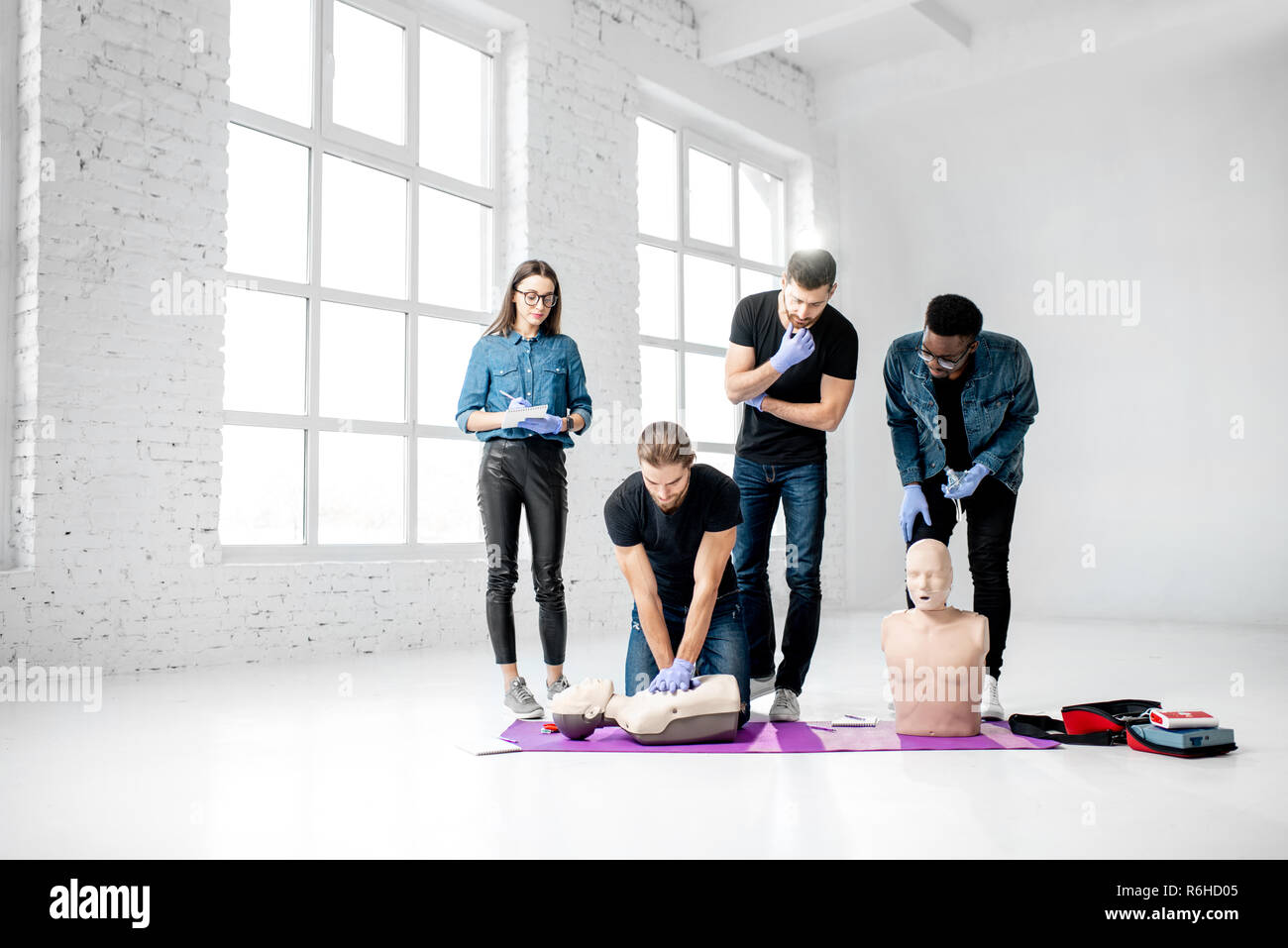 Group of young people practising to make artificial breathing with ...