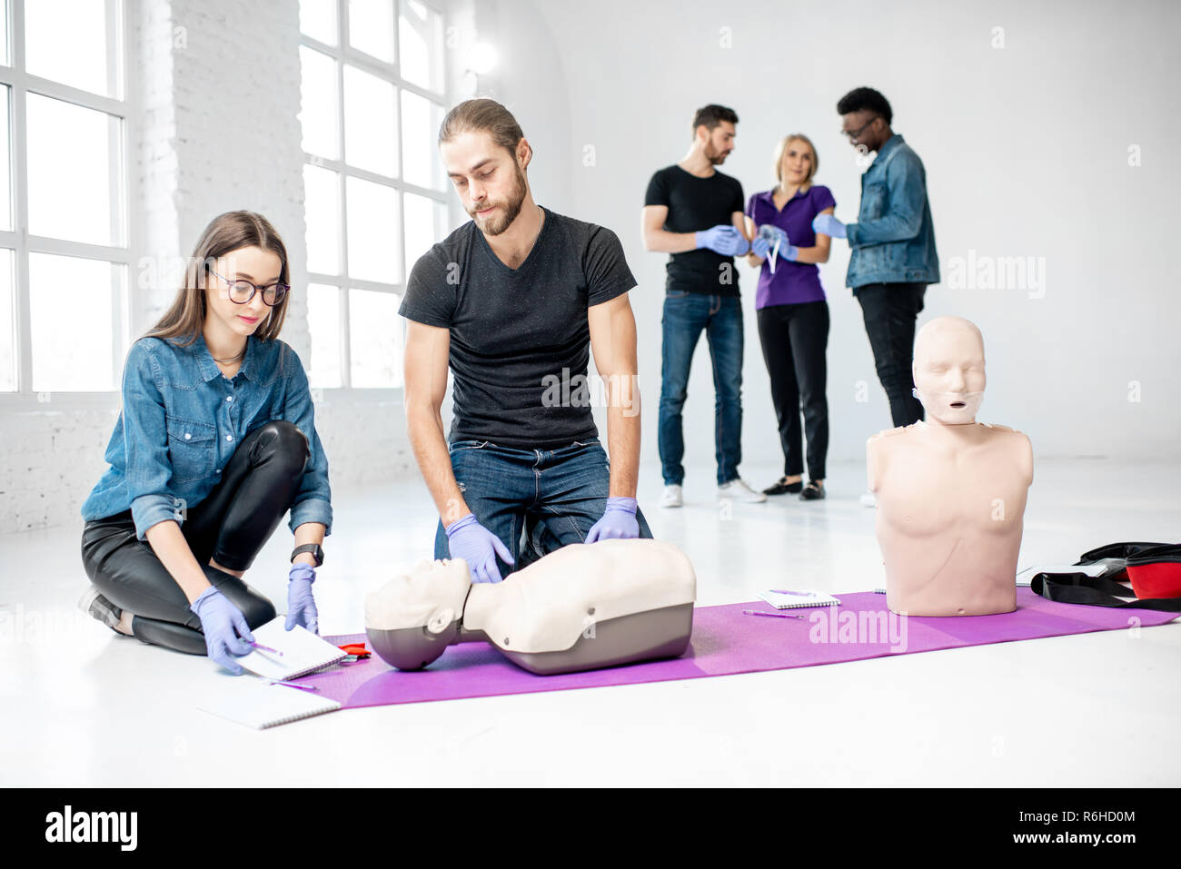 Group of young people practising to make artificial breathing with ...