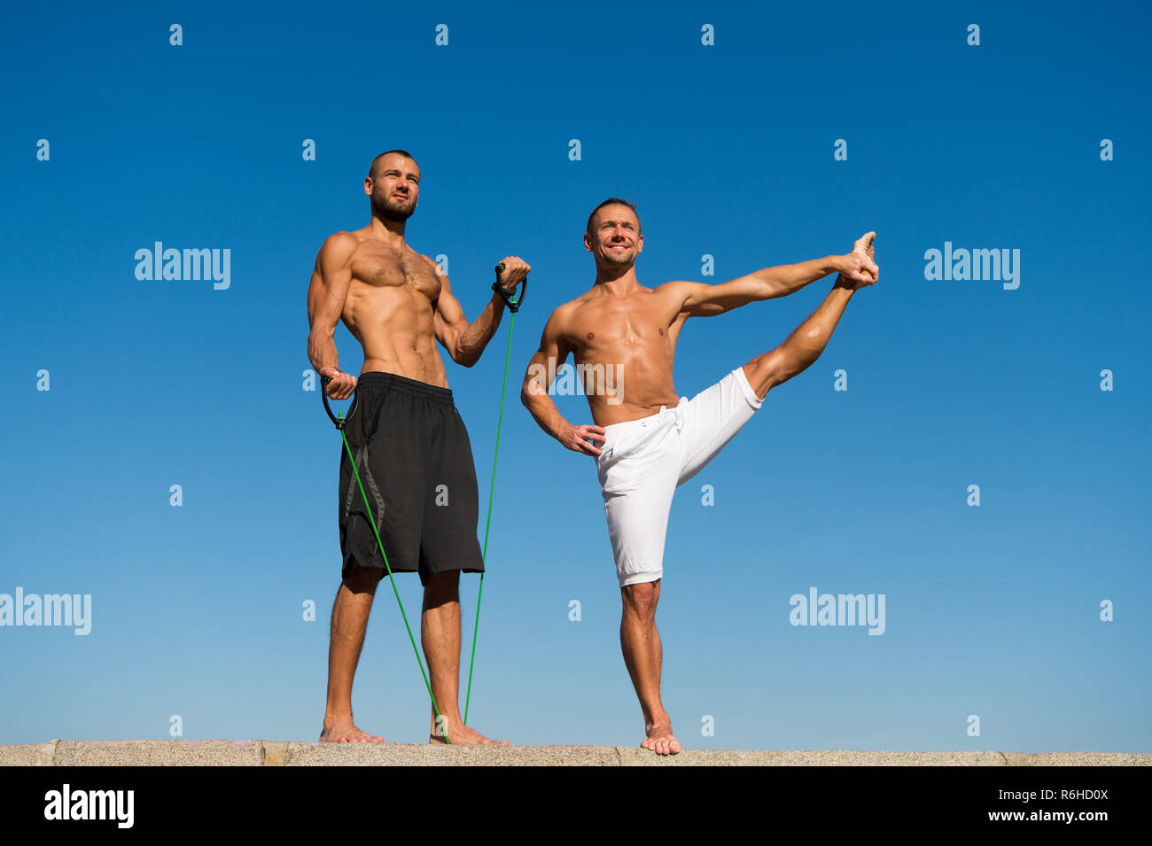 Muscular men training on fresh air. Reach balance by virtue of yoga ...