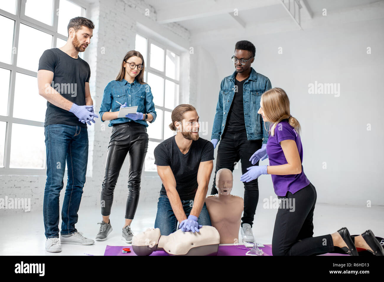 Group of young people practising to make artificial breathing with ...