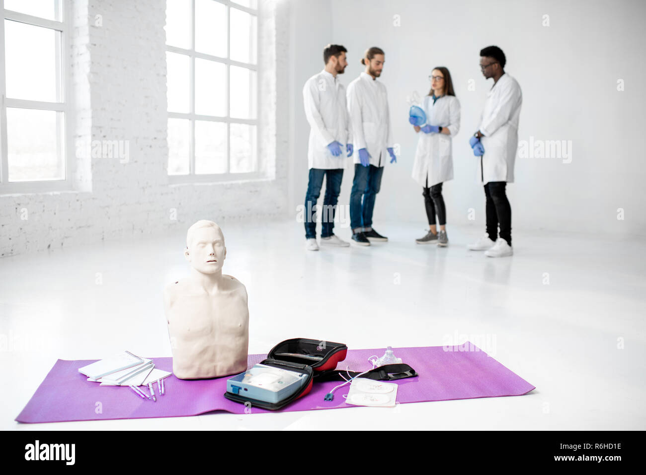 First aid medical stuff and dummies with group of young medics standing ...
