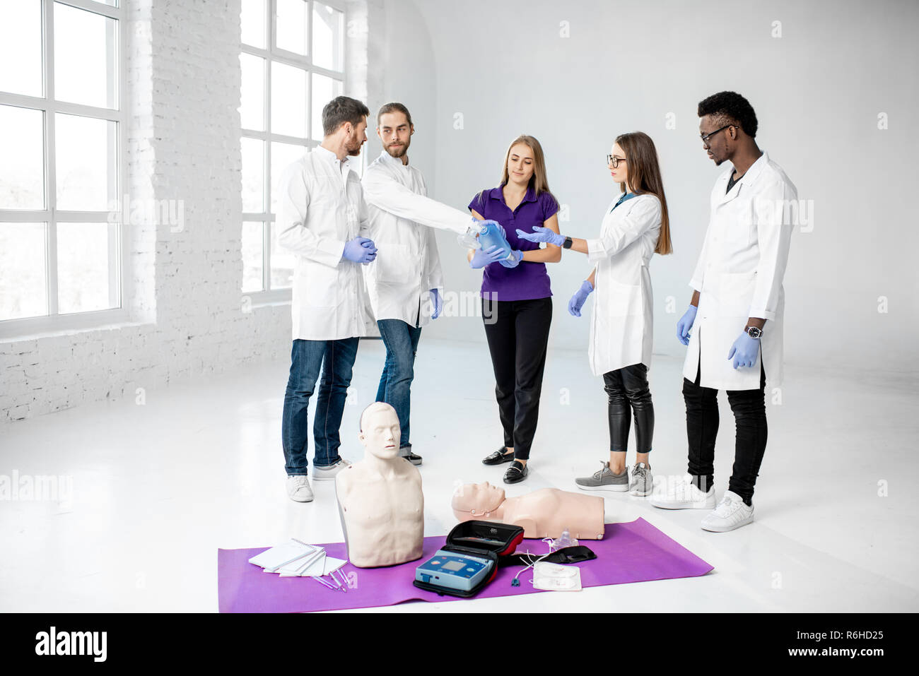 Group of young medics standing and talking together during the break of ...