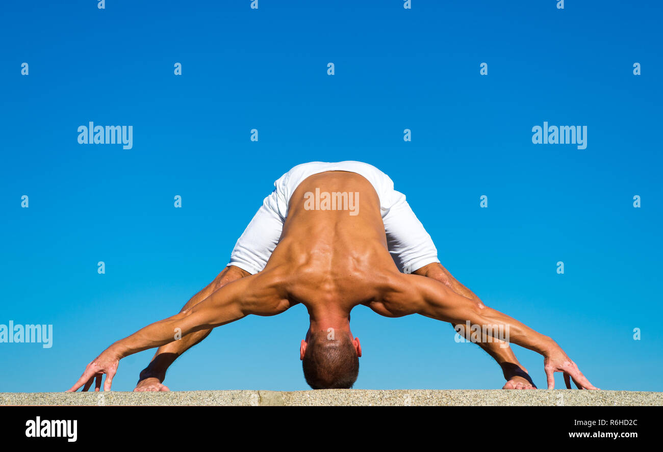 Yoga instructor with muscular body stretching. Sport and health care ...