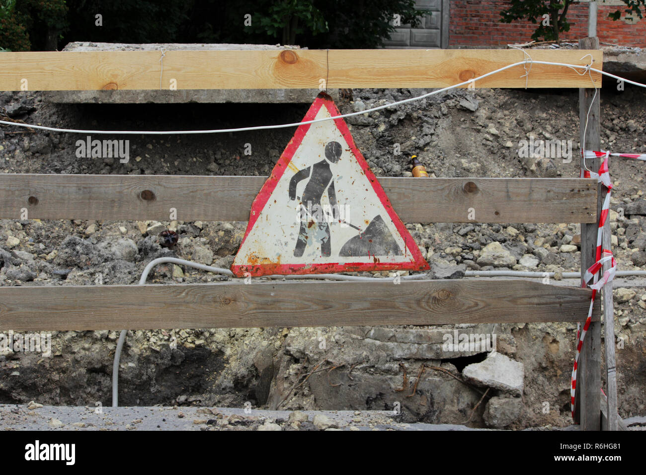 An old triangular sign of construction work with a digging man hanging ...