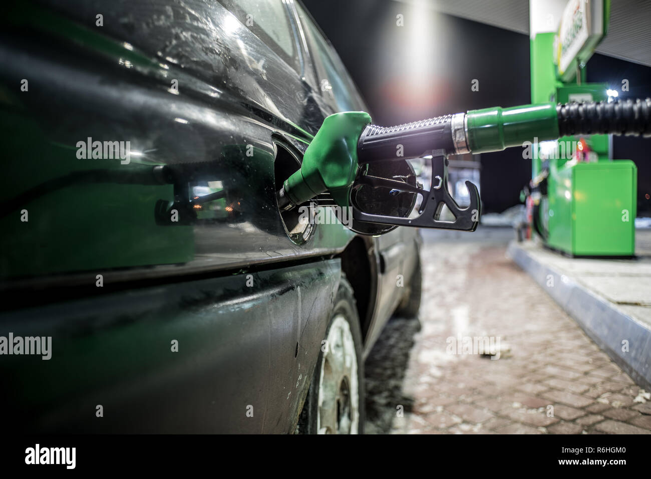 Fueling nozzles at filling station close up at night Stock Photo - Alamy